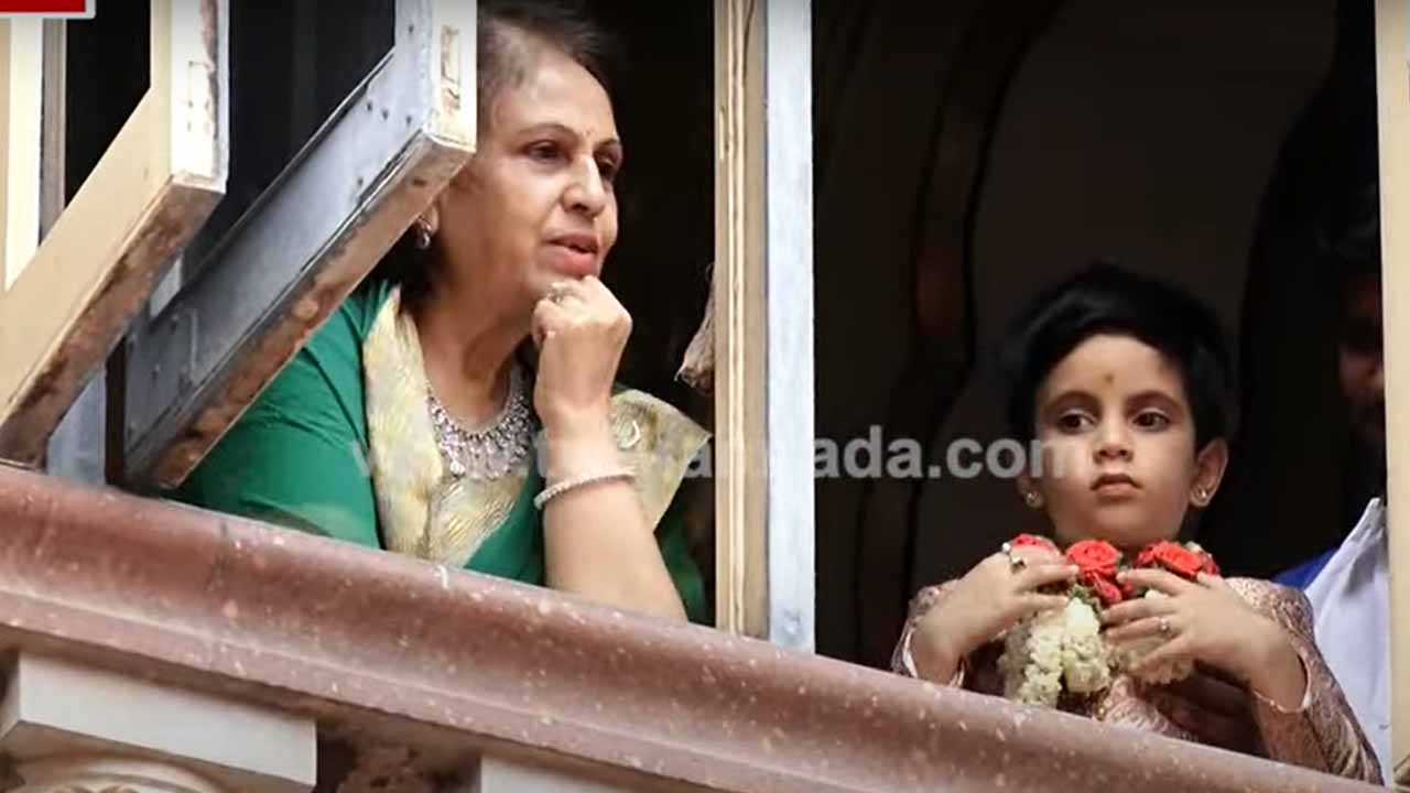 Rajmatha Pramoda Devi watches Ayudha Puje with her grandson from a ...
